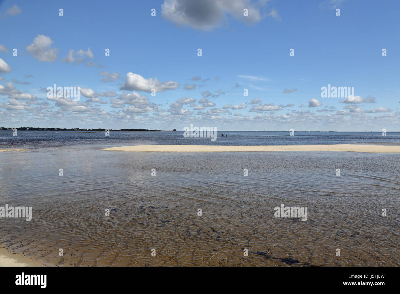 Shallow sandy ocean coastline off the Gulf of Mexico with blue sky and ...