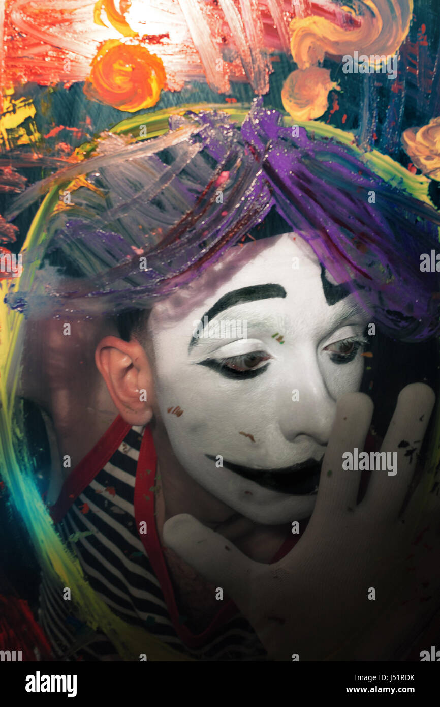 Face of Mime behind glass with multi-colored paint stains closeup Stock ...