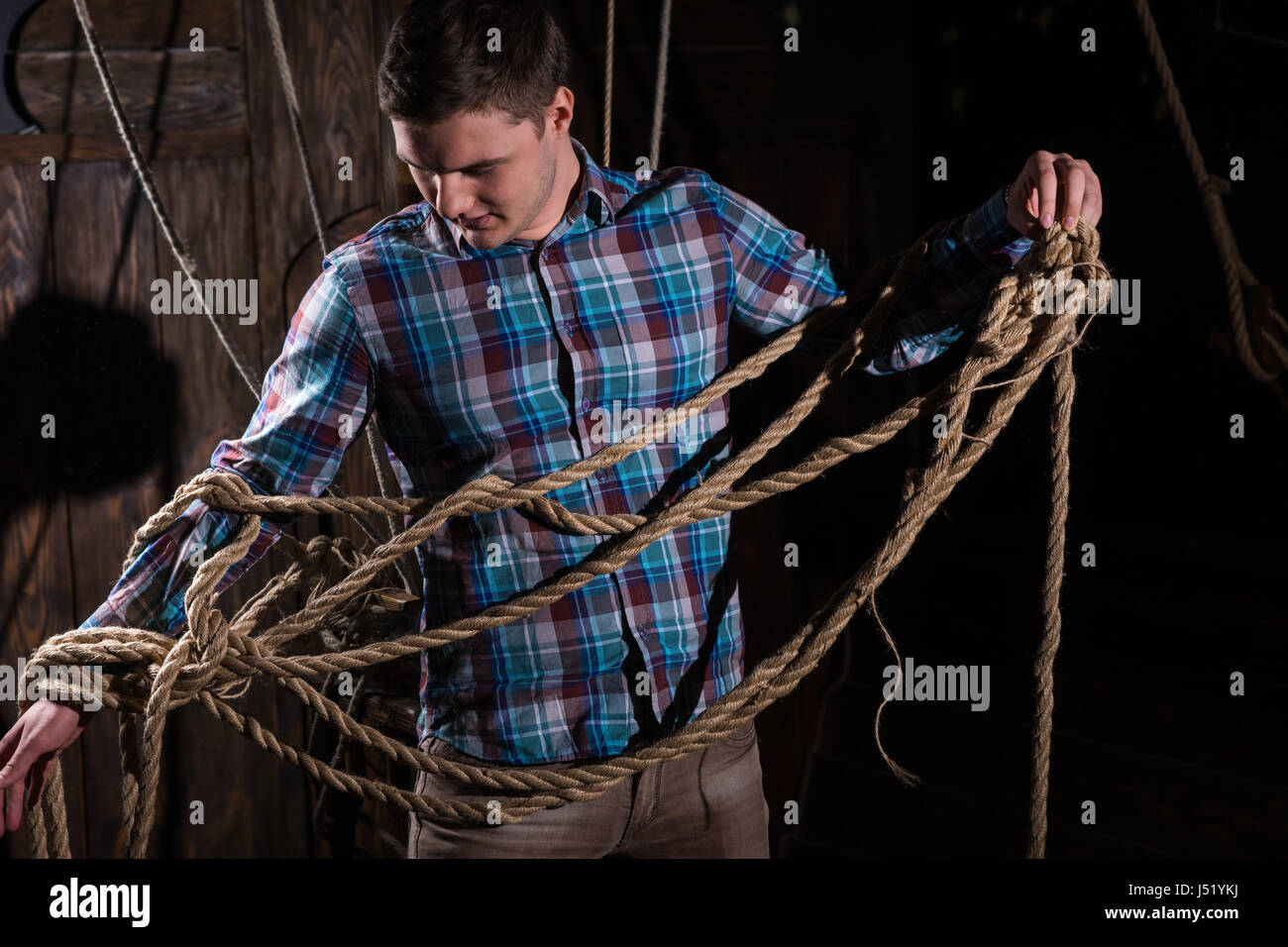 Young man freed from captivity and selecting from ropes, escape the ...