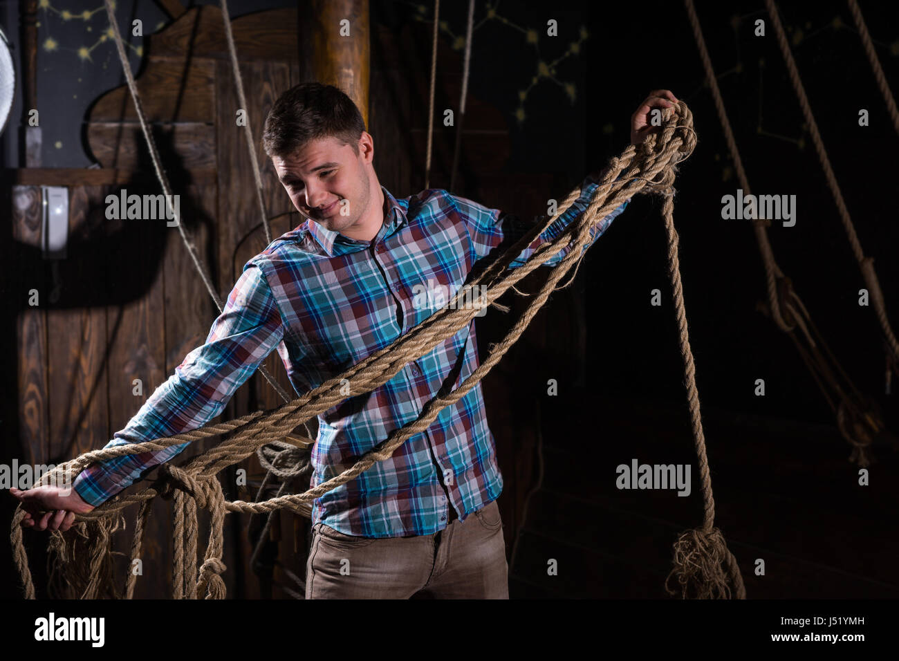 Young guy freed from captivity and selecting from ropes, escape the ...