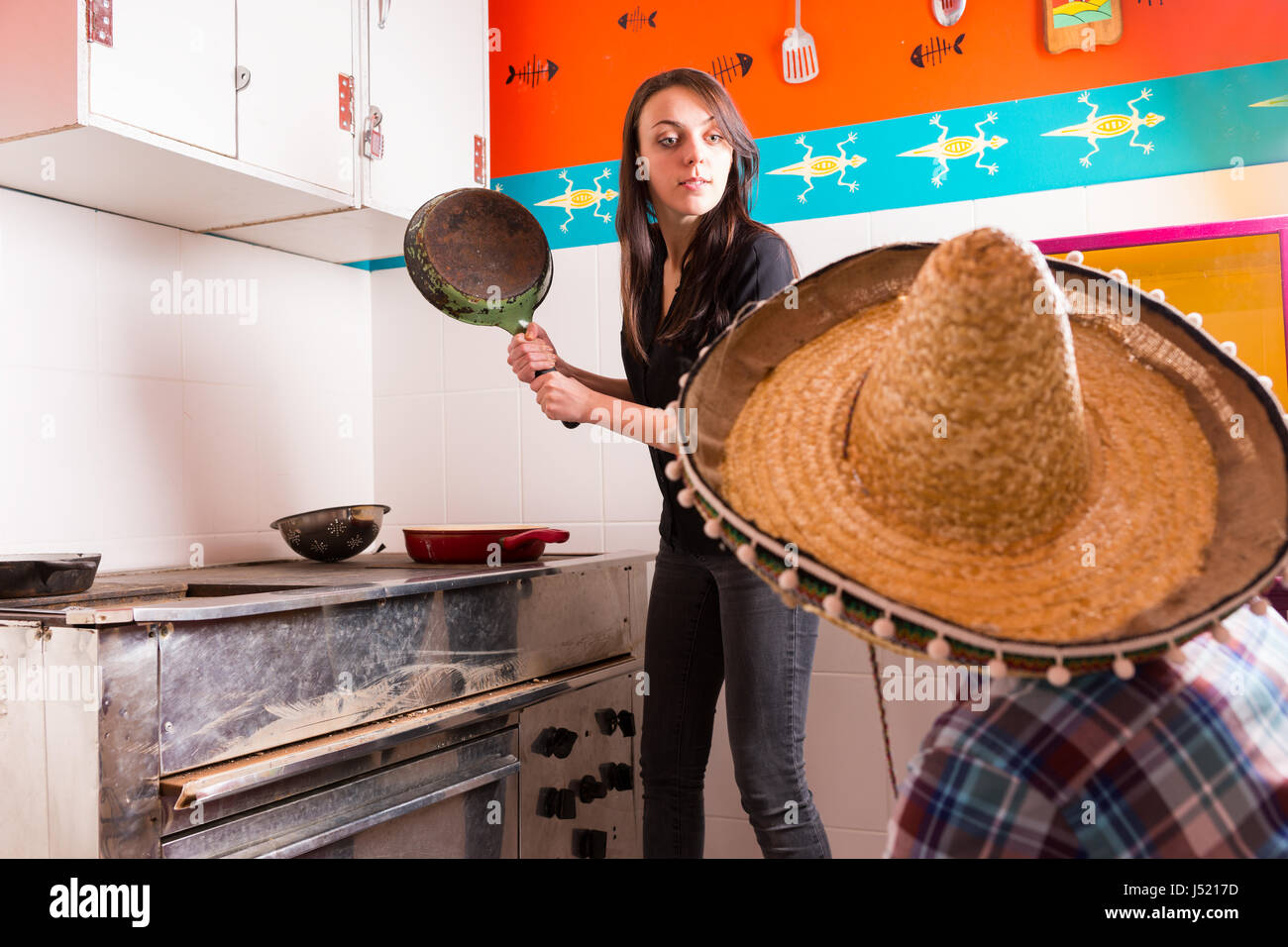 Young woman brandishing a frying pan at a man in sombrero while ...