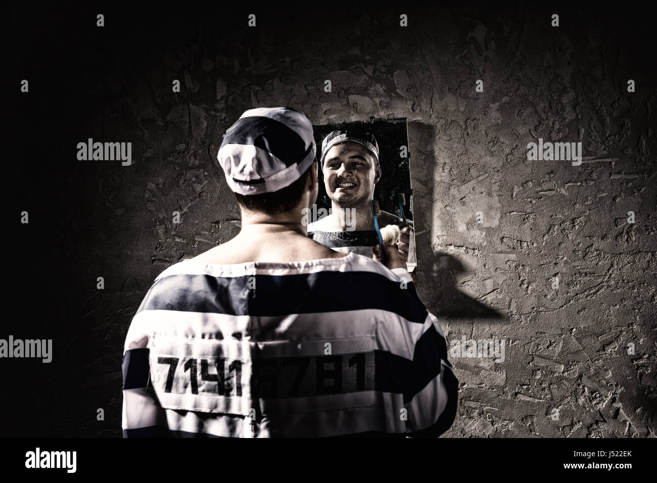 Prisoner wearing prison uniform with sewed number standing with ...