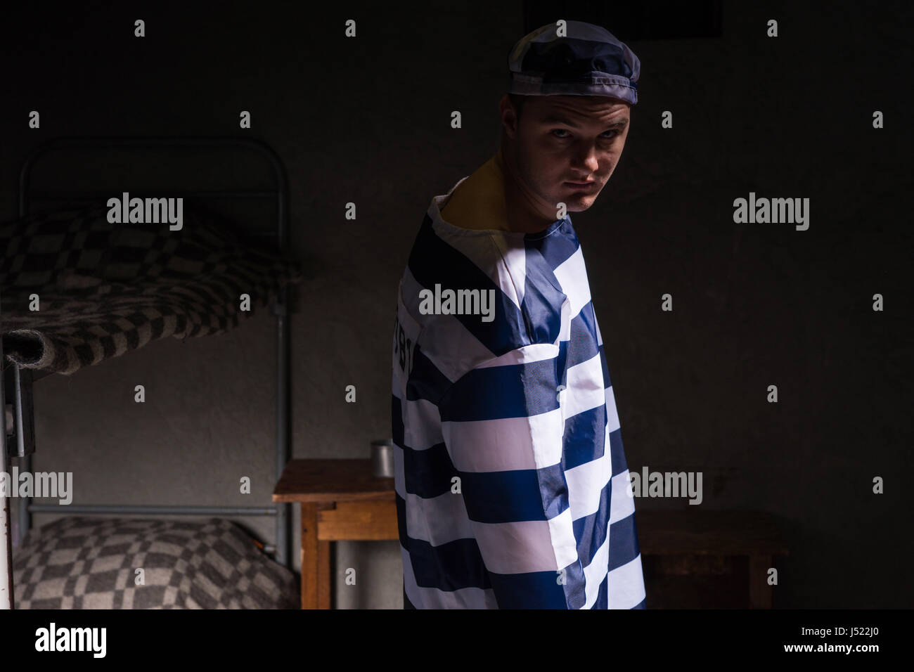 Prisoner looked back with an angry look wearing prison uniform standing ...