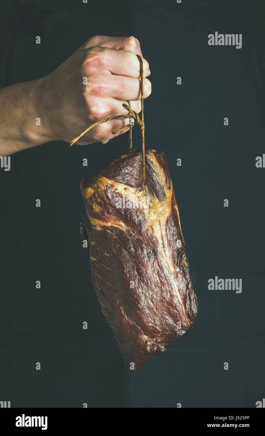 Man' s hand holding cut of cured pork meat at local farmers market ...