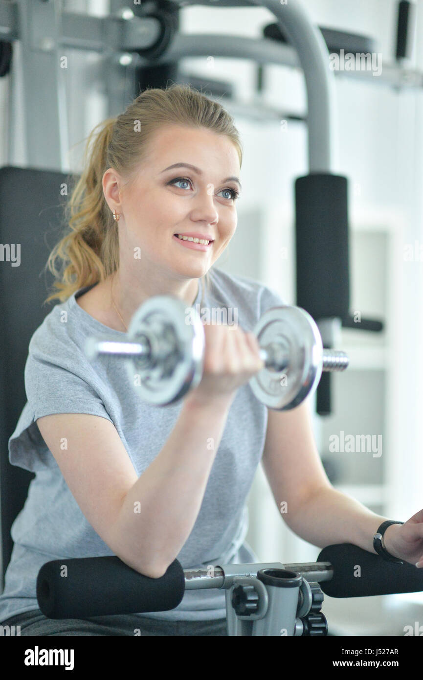 Young woman in a gym with a dumbbell Stock Photo - Alamy
