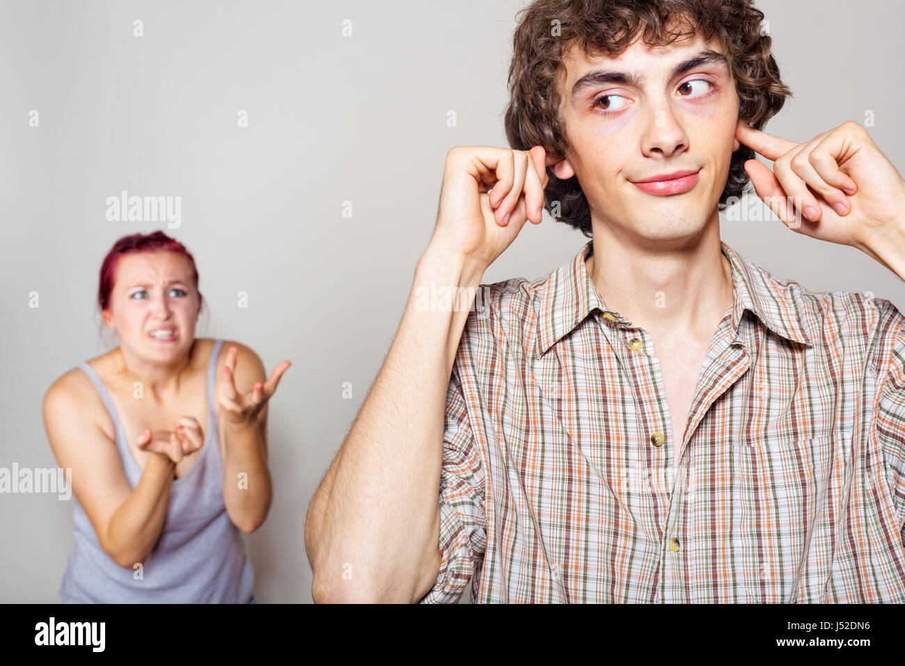 An angry woman yelling at her husband, happy man closed his ears with ...