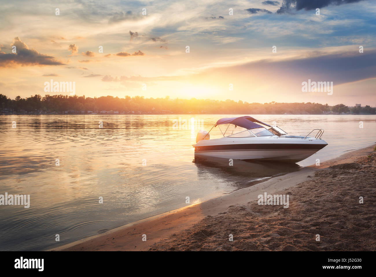 Colorful sunset with boat ot the river bank. Summer landscape with ...