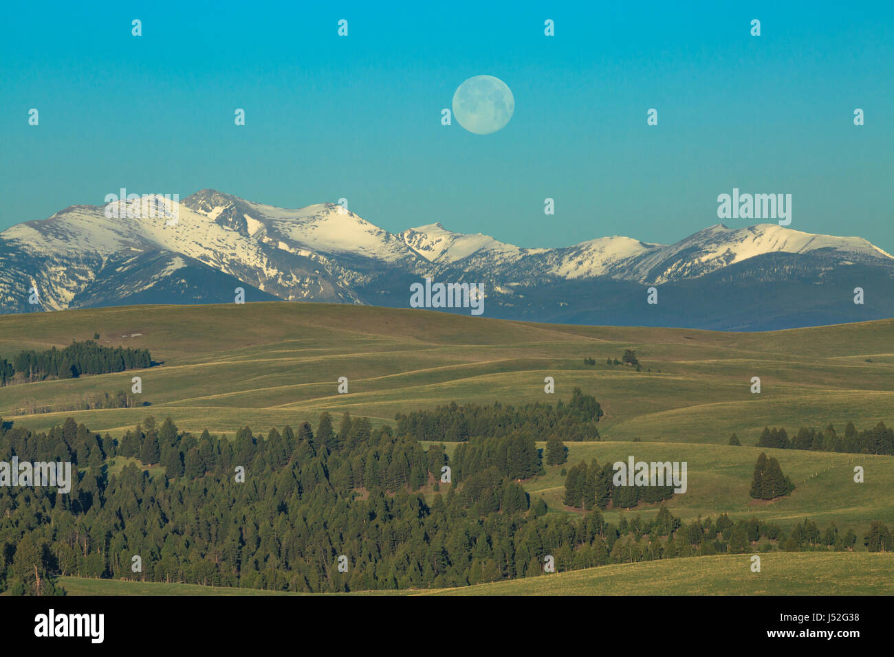 full moon setting over the flint creek range and foothills of upper ...