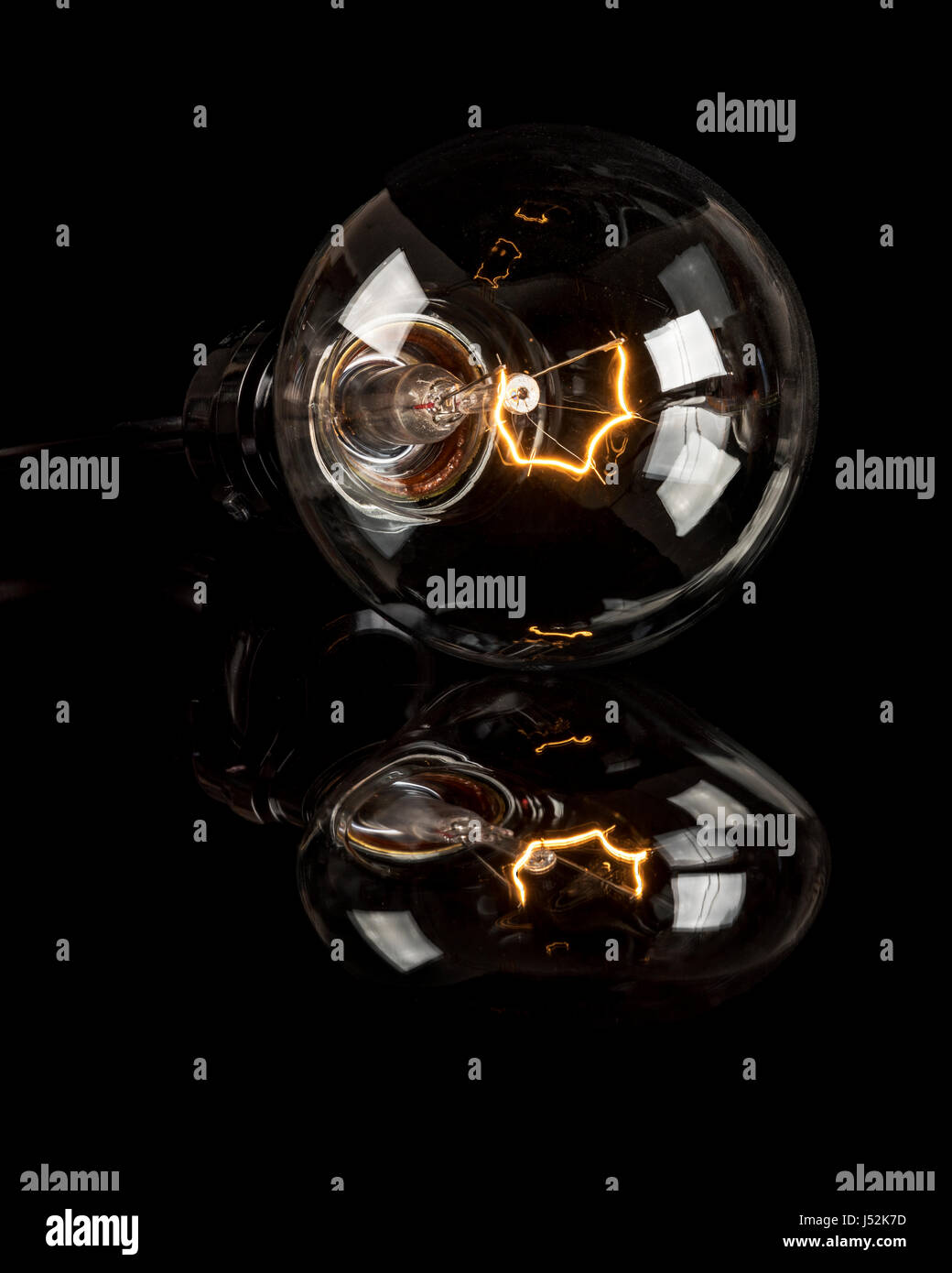 Clear glass light bulb glowing bright with electricity Stock Photo - Alamy