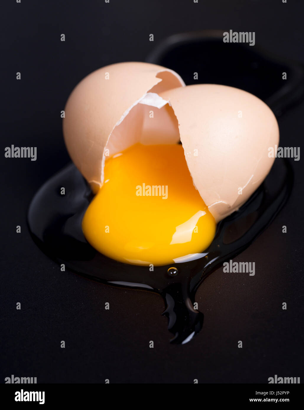 Cracked egg - closeup on the black background Stock Photo - Alamy