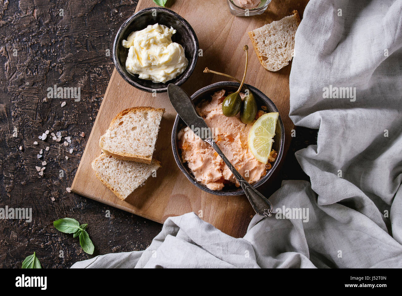 Black bowl of salmon pate with red caviar served with butter, sliced ...