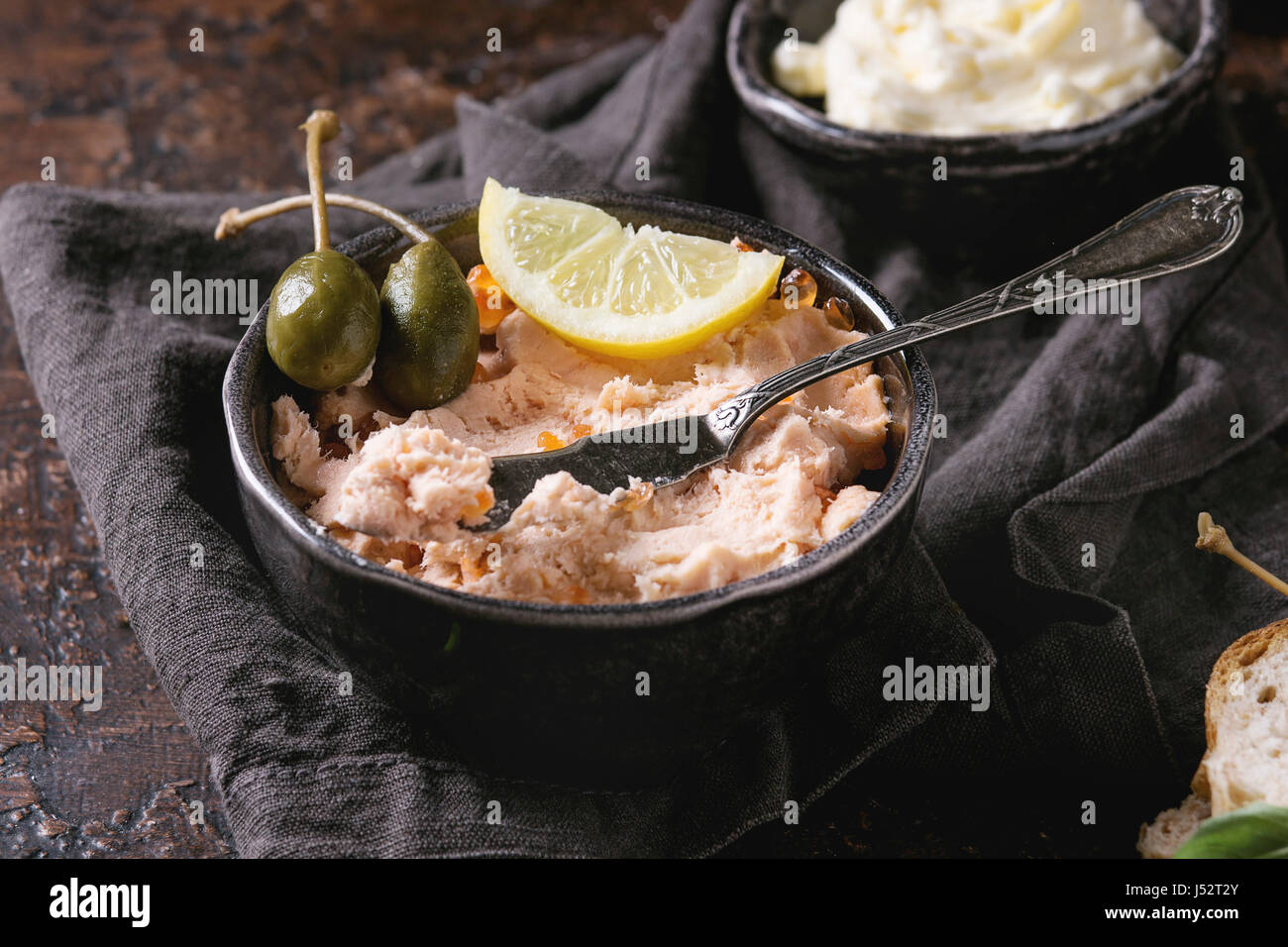 Black bowl of salmon pate with red caviar served with butter, sliced ...