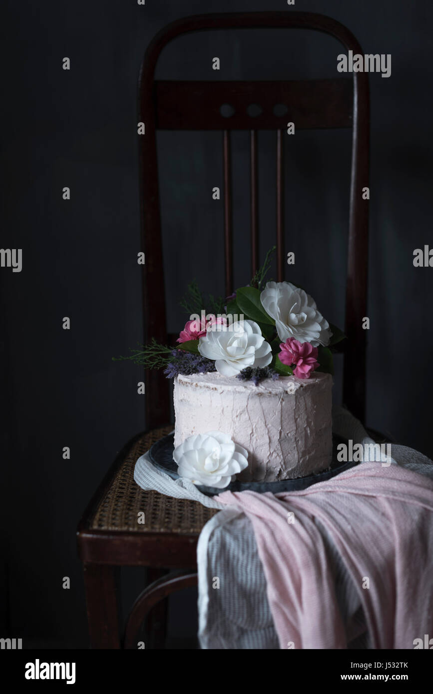 An iced cake decorated with flowers, on a chair Stock Photo - Alamy