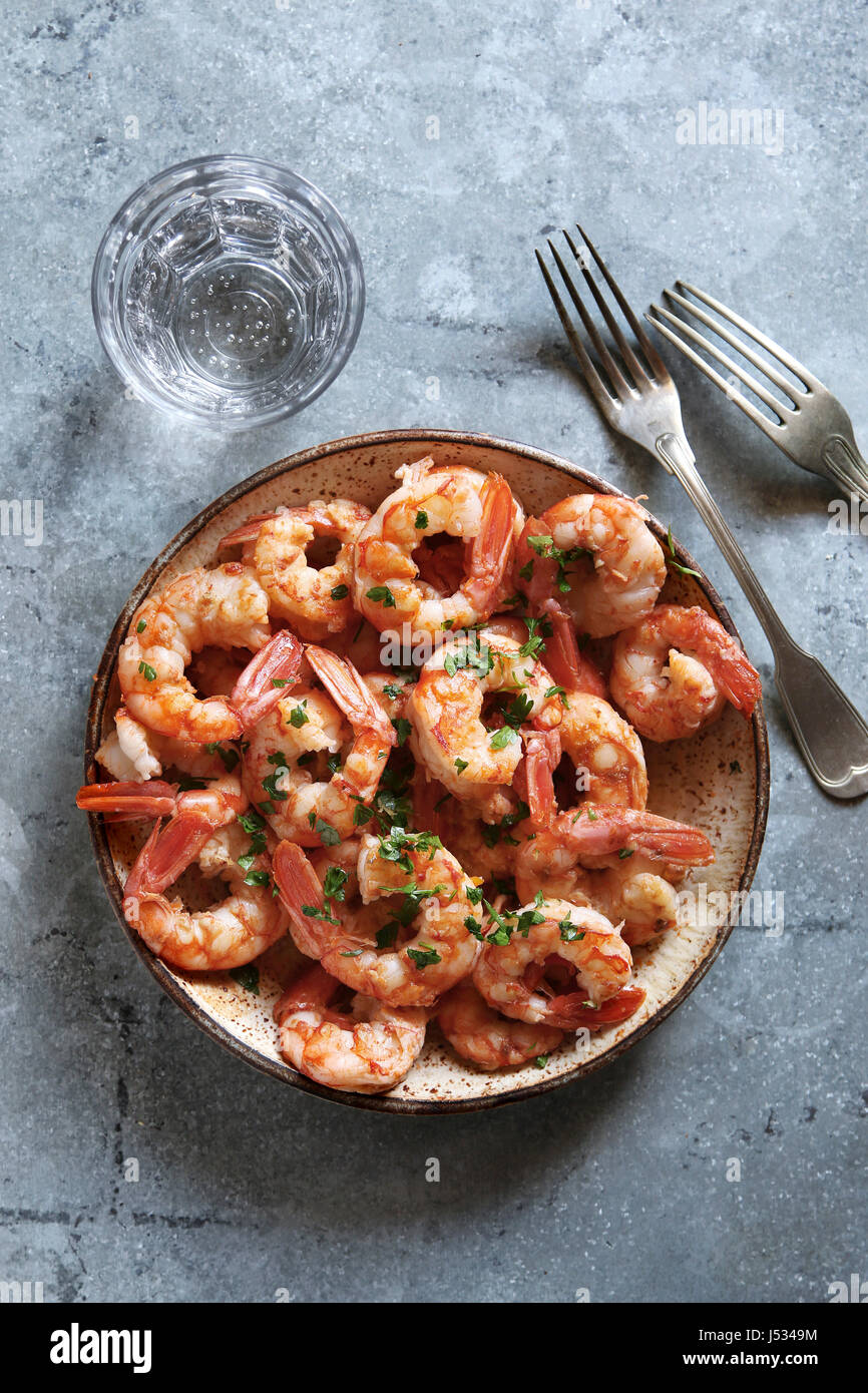 Sauteed shrimp with garlic,parsley and anchovy butter on a plat with a ...