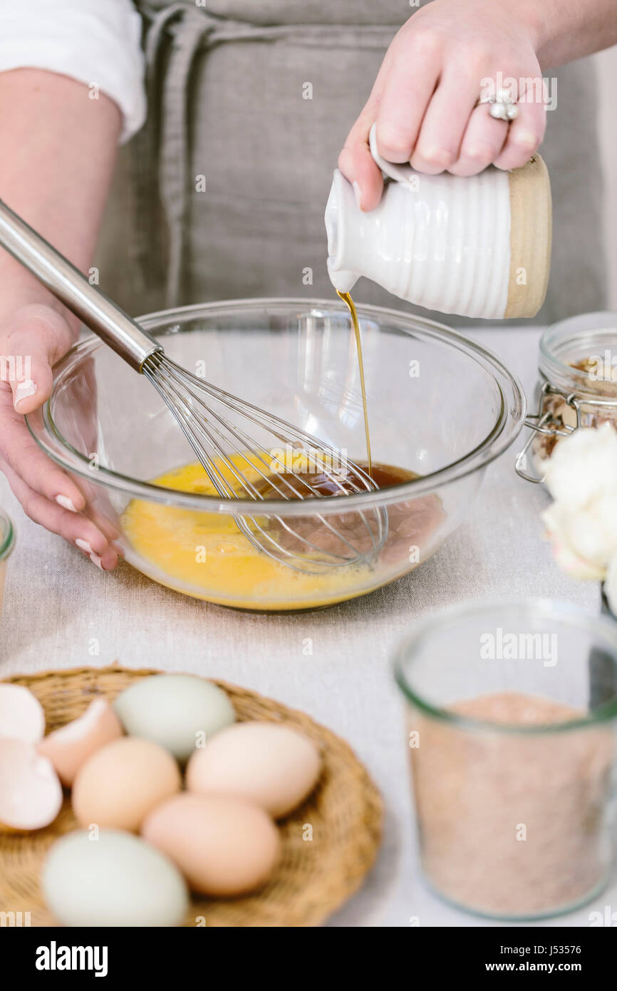 A woman is photographed as she is pouring maple syrup into an egg ...