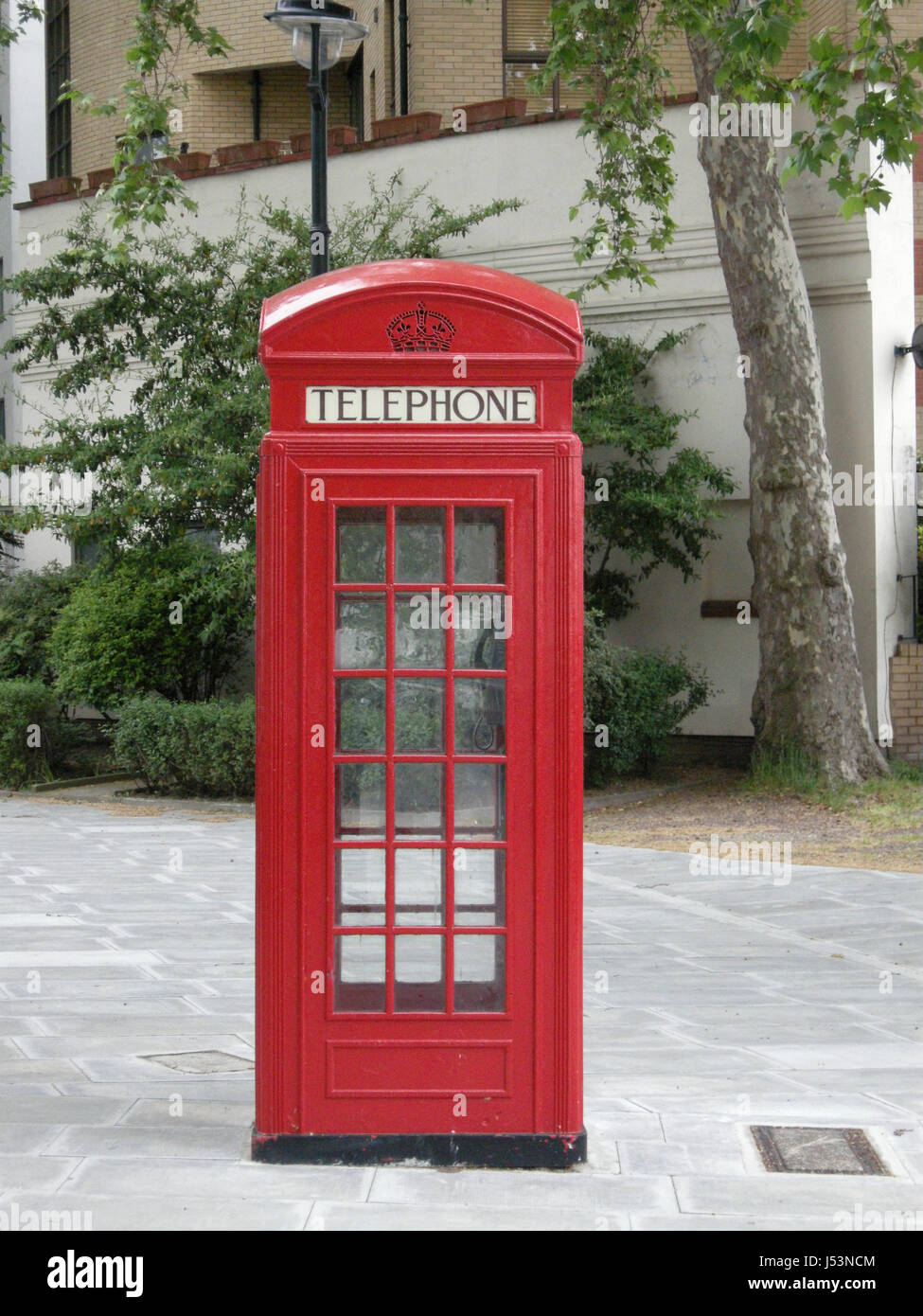 Traditional British red telephone box in the middle of a pavement in ...
