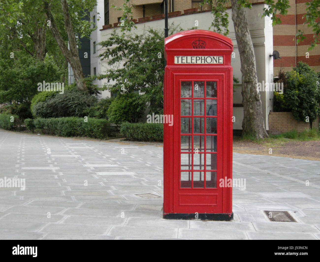 Traditional British red telephone box in the middle of a pavement in ...