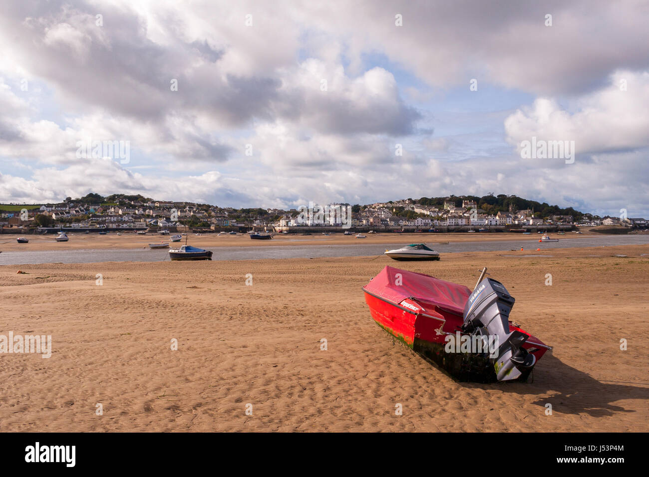 A red boat rests the sand, Instow beach on a sunny day in Devon Stock ...