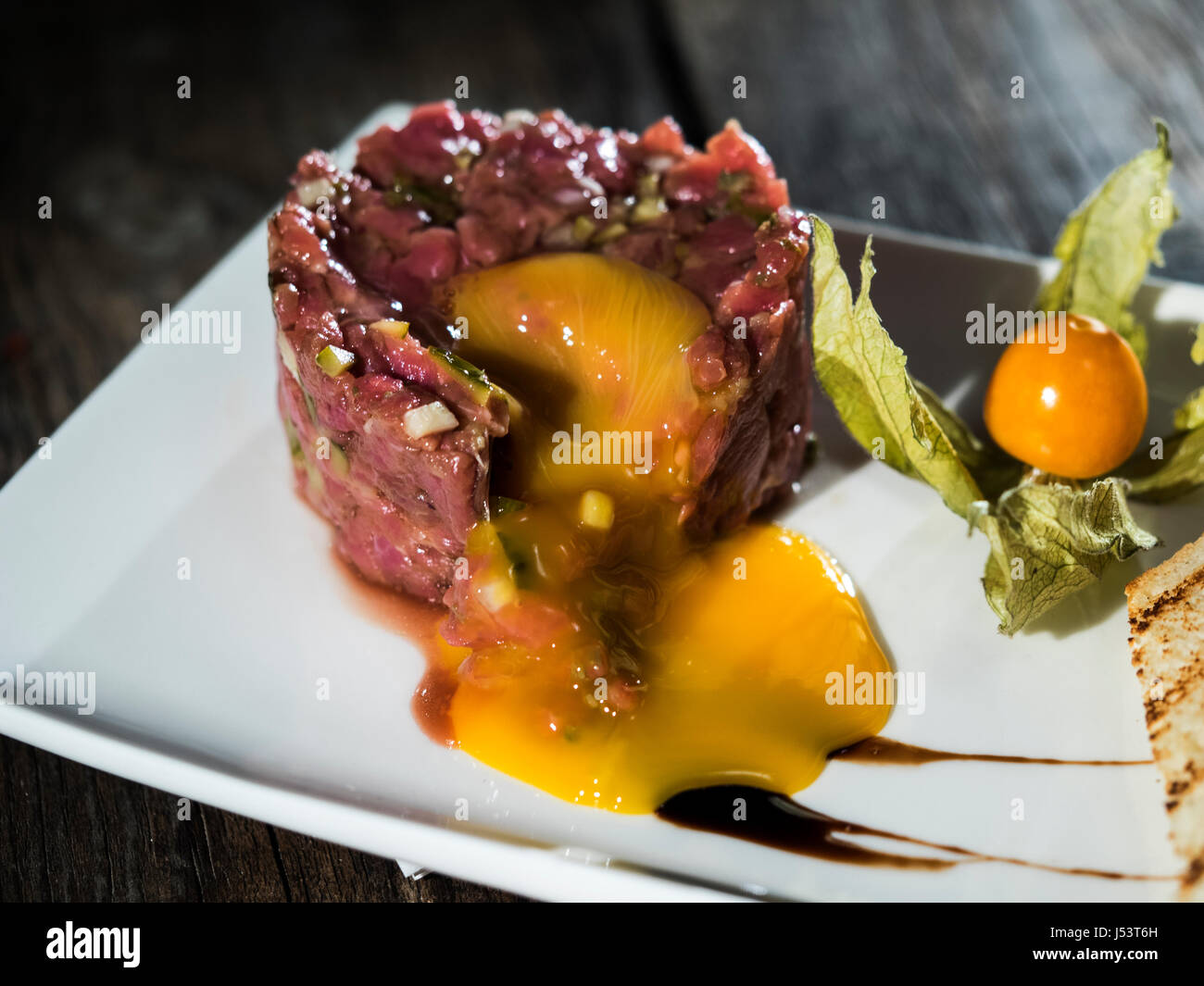 Raw steak tatar with egg yolk Stock Photo - Alamy