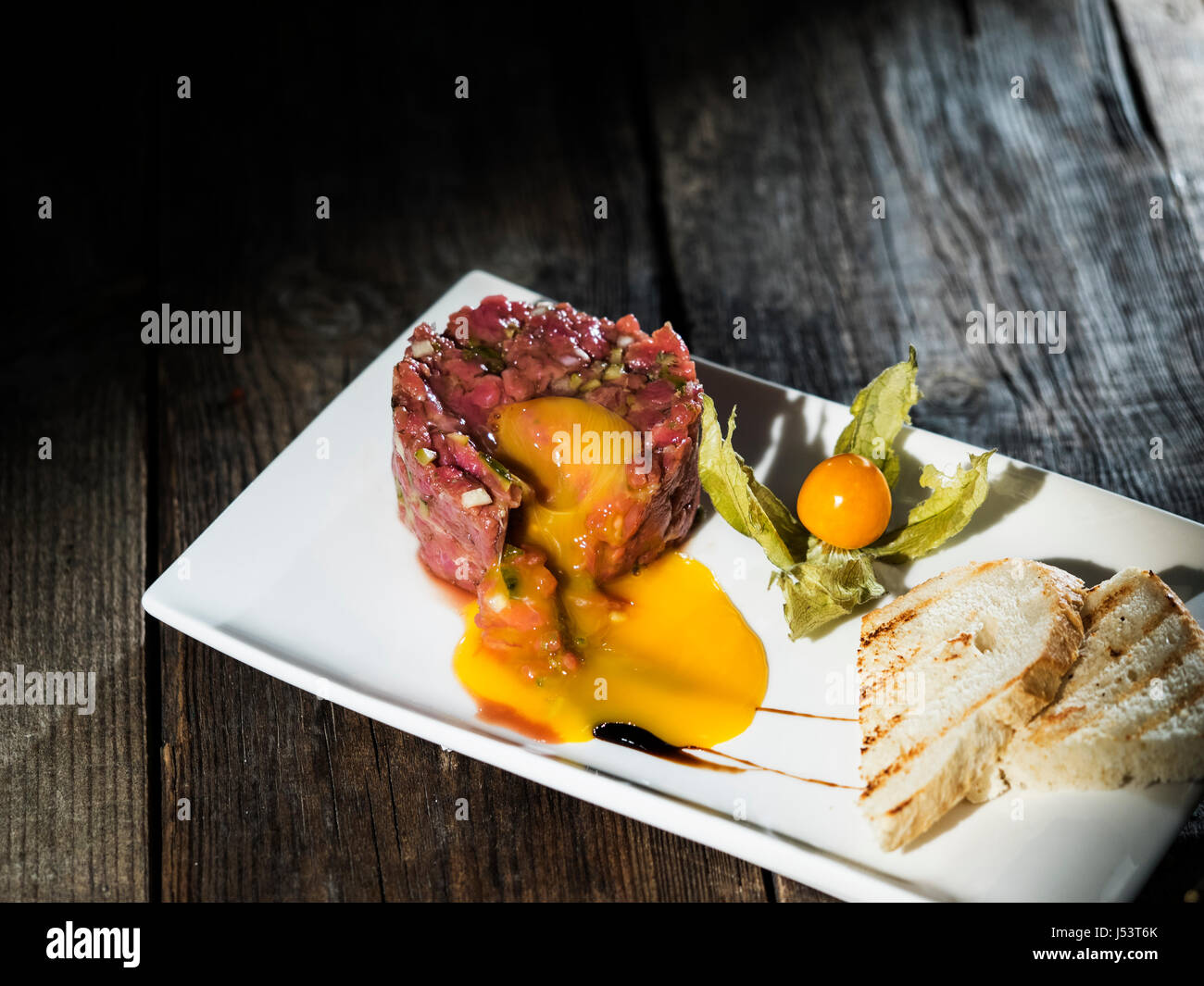 Raw steak tatar with egg yolk Stock Photo - Alamy