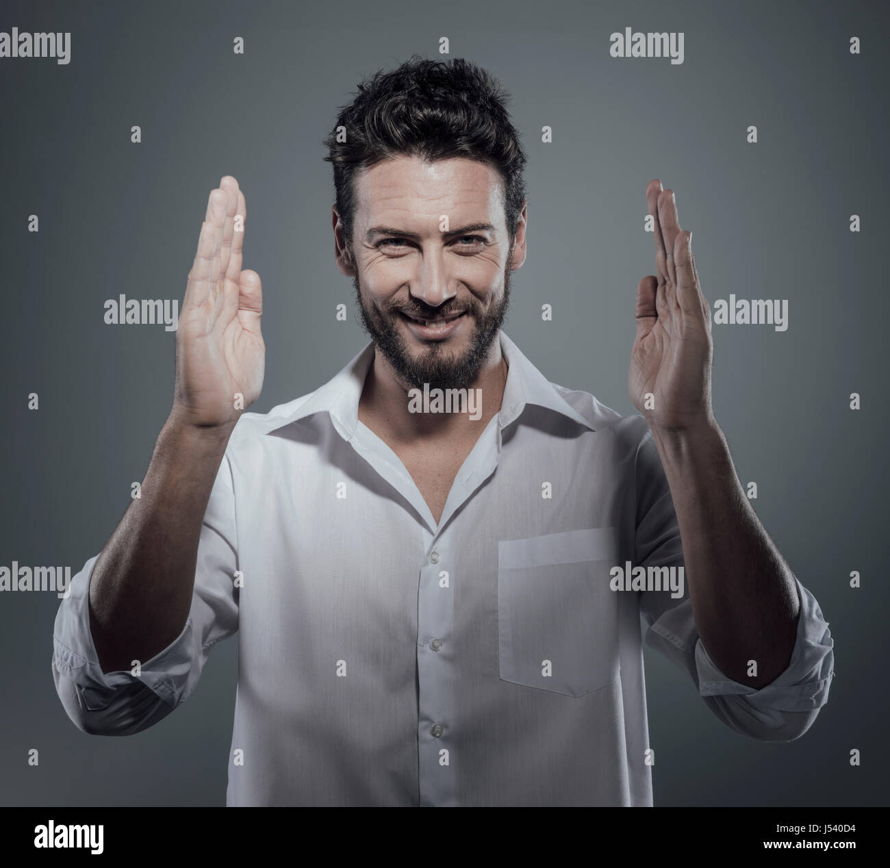 Handsome young man with raised hands, measure concept Stock Photo - Alamy