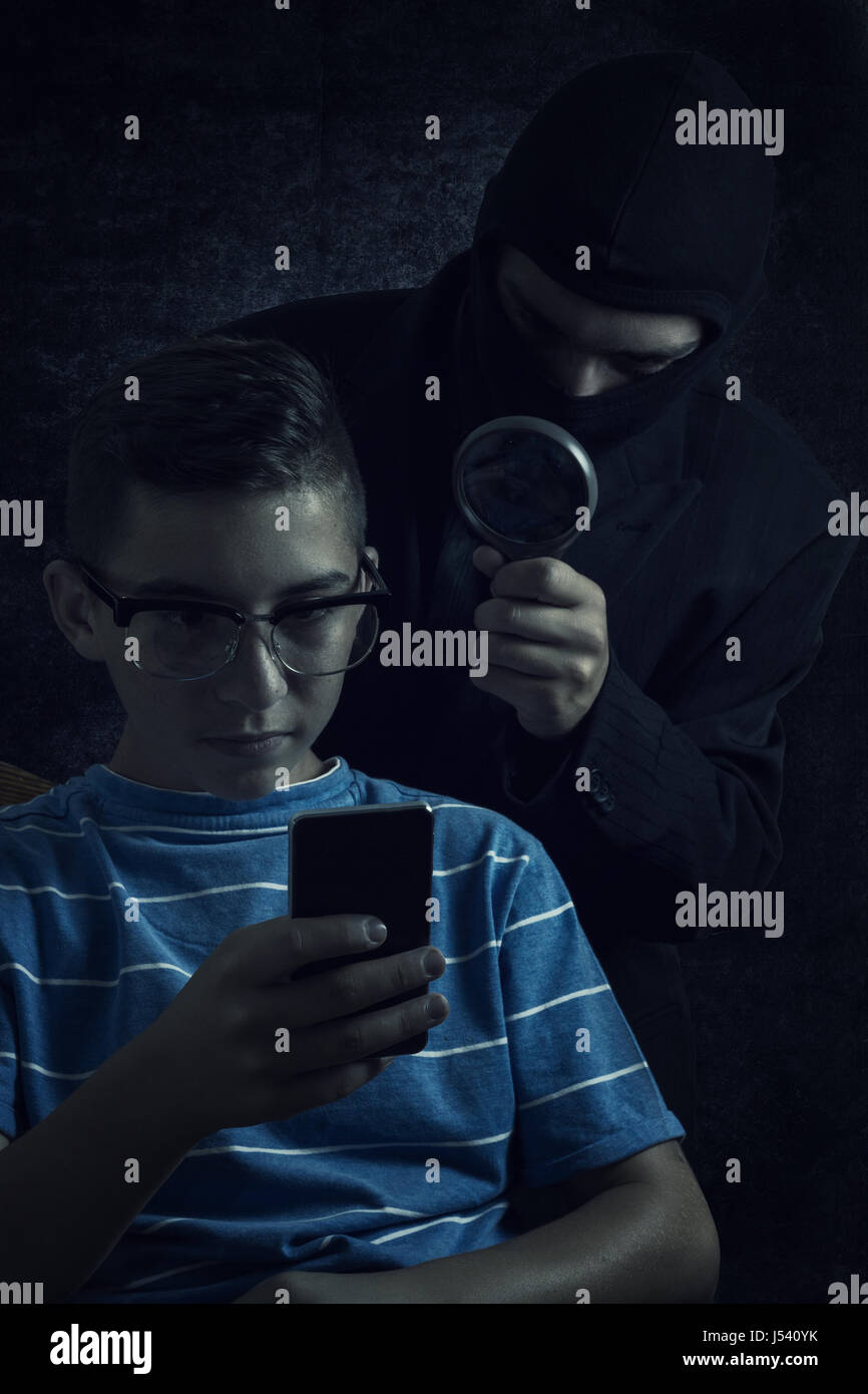 masked man spying data from smartphone of teen Stock Photo - Alamy