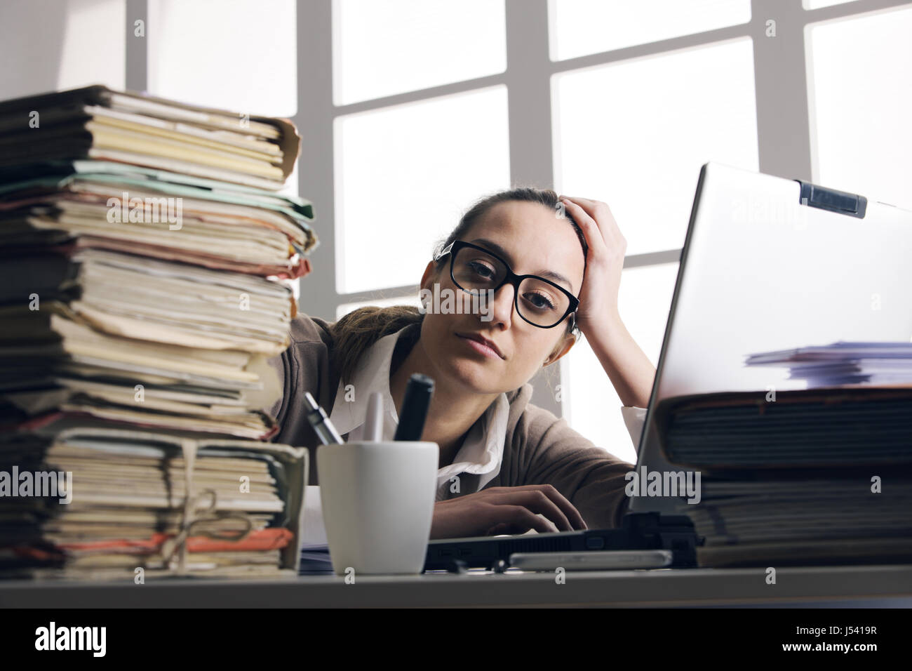 Young tired businesswoman with tons of documents Stock Photo - Alamy