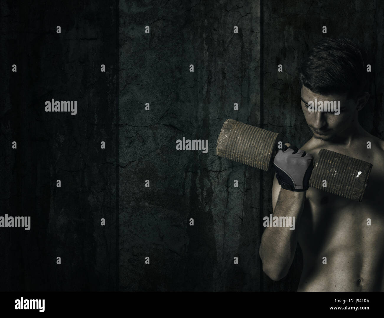 power athletic young bodybuilder doing exercises with rusty dumbbell ...