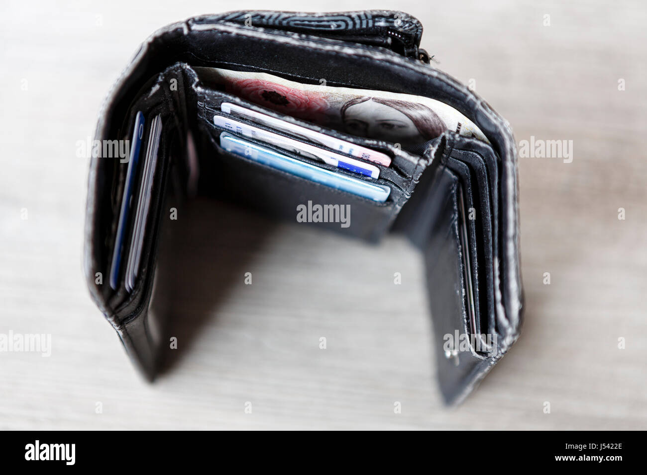 open black woman wallet with money and id cards on the wooden table ...