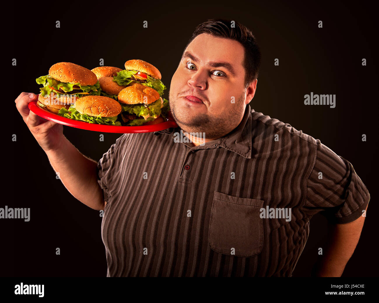 Fat man eating fast food hamberger. Breakfast for overweight person ...