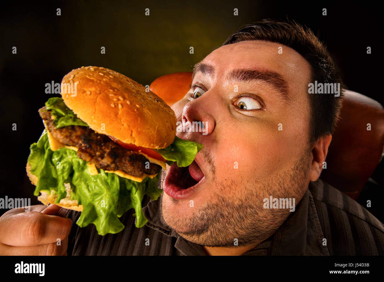 Fat man eating fast food hamberger. Breakfast for overweight person ...
