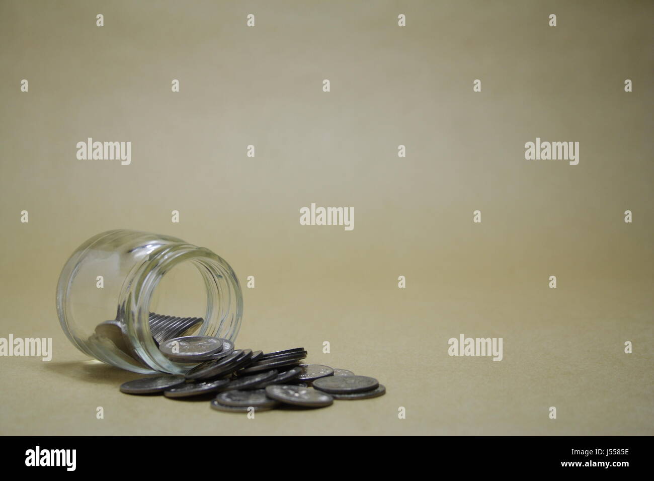Silver Coins Spilling from Jar Stock Photo - Alamy