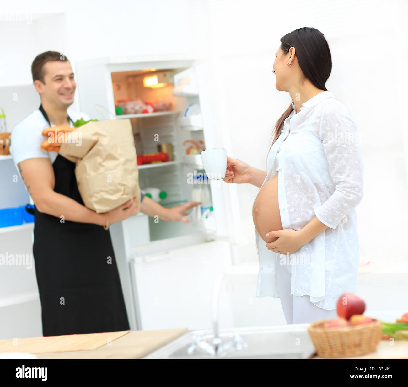 Happy pregnant woman and her husband cook food in the kitchen Stock ...