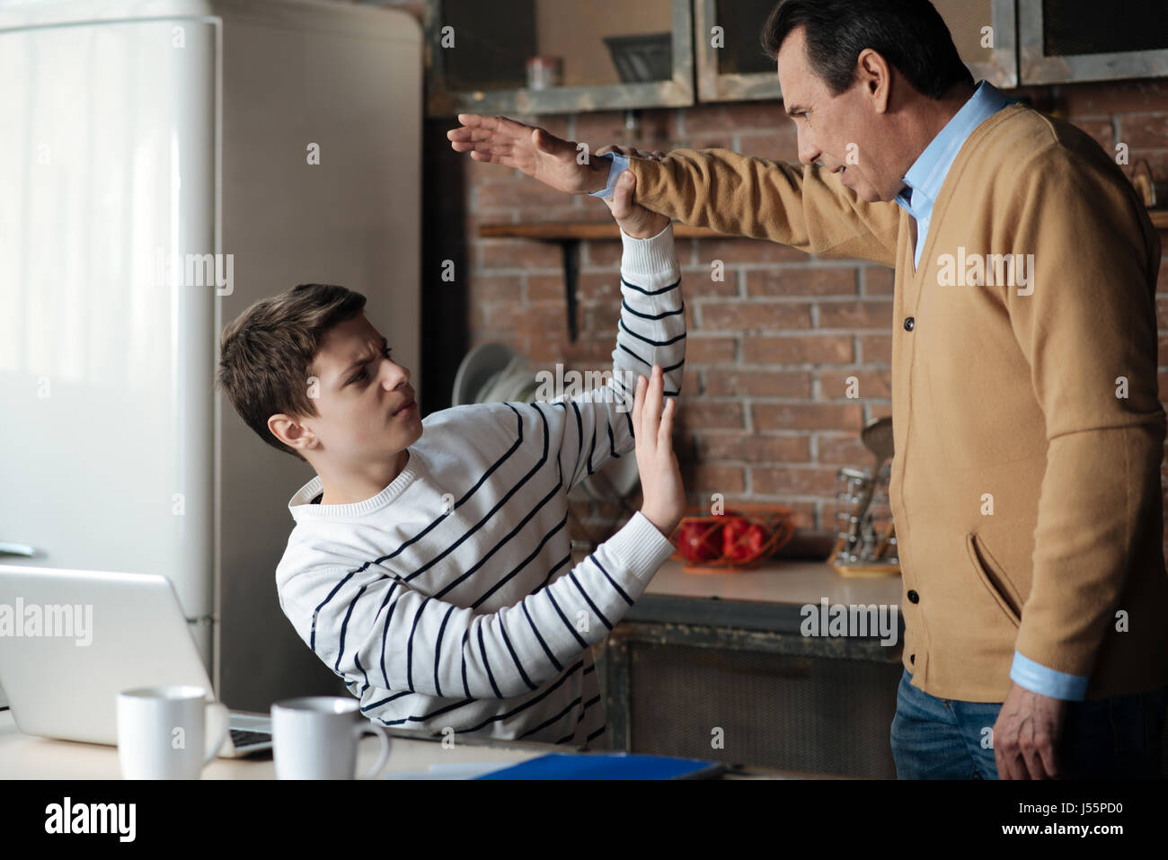 Angry strong teenager catching hand over his head Stock Photo - Alamy