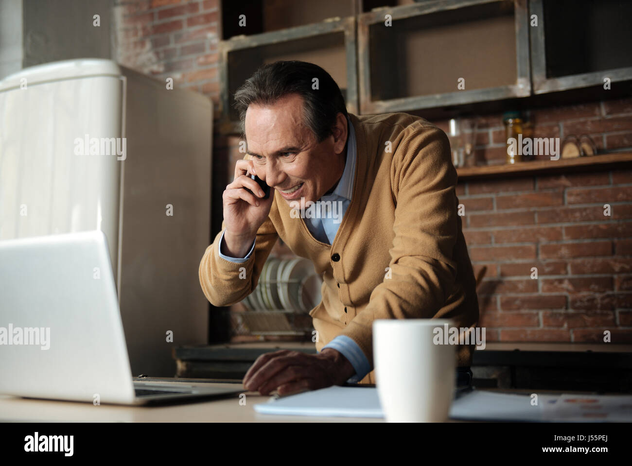 Attractive smiling man looking at his computer Stock Photo - Alamy