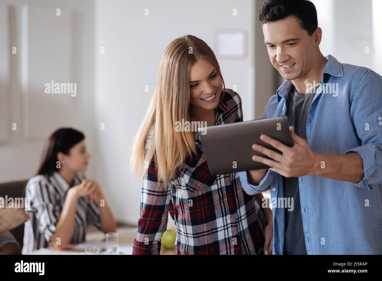 Handsome male person standing near his beautiful colleague Stock Photo ...