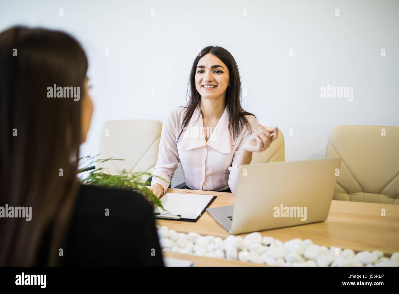 Two pretty female colleagues in modern office Stock Photo - Alamy