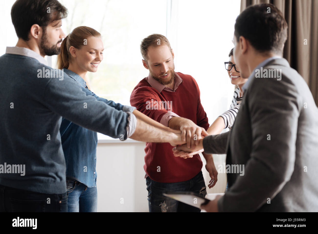 Team of five colleagues holding hands together Stock Photo - Alamy
