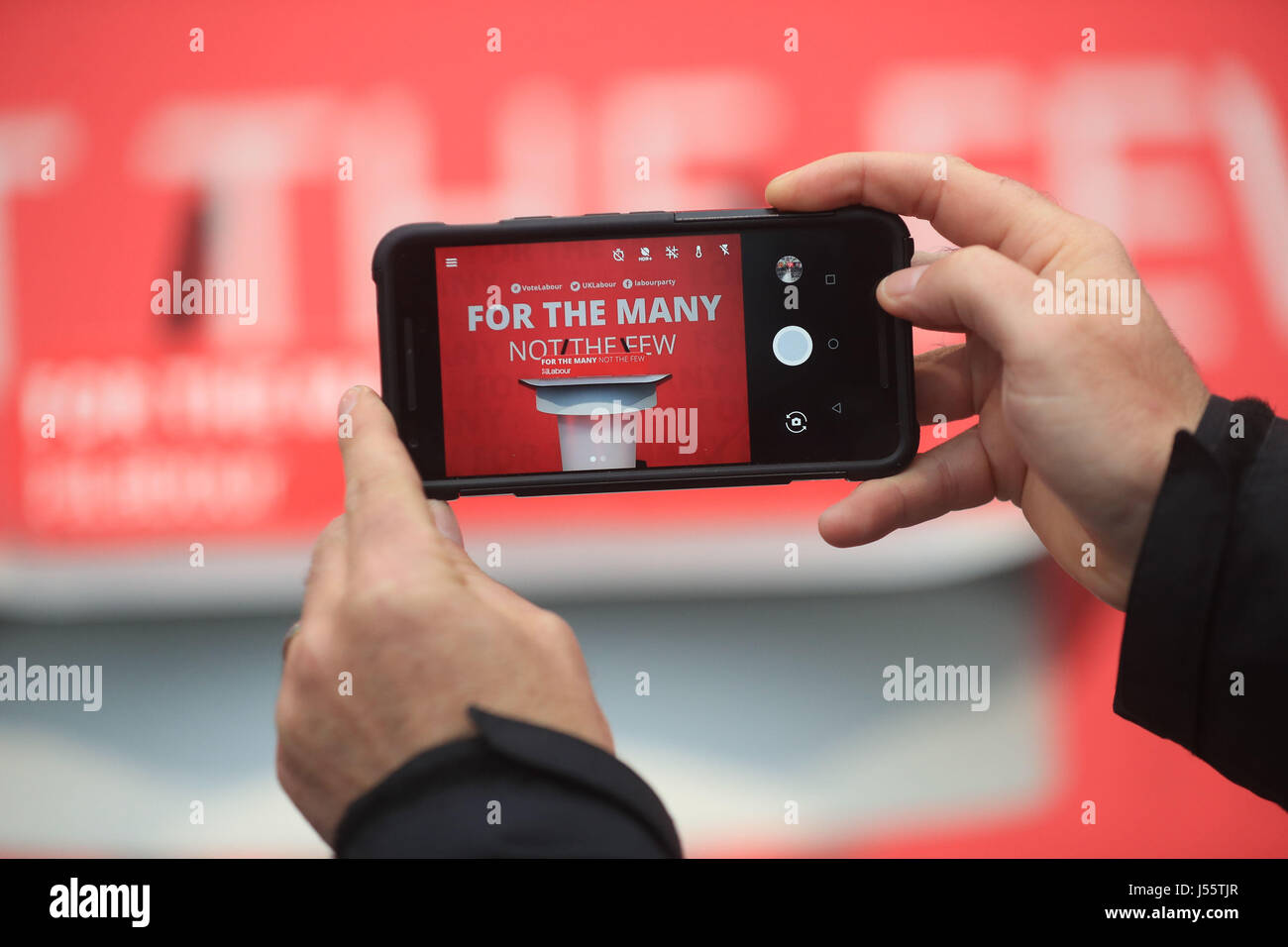 An audience member points a mobile phone camera at the lectern ahead of ...