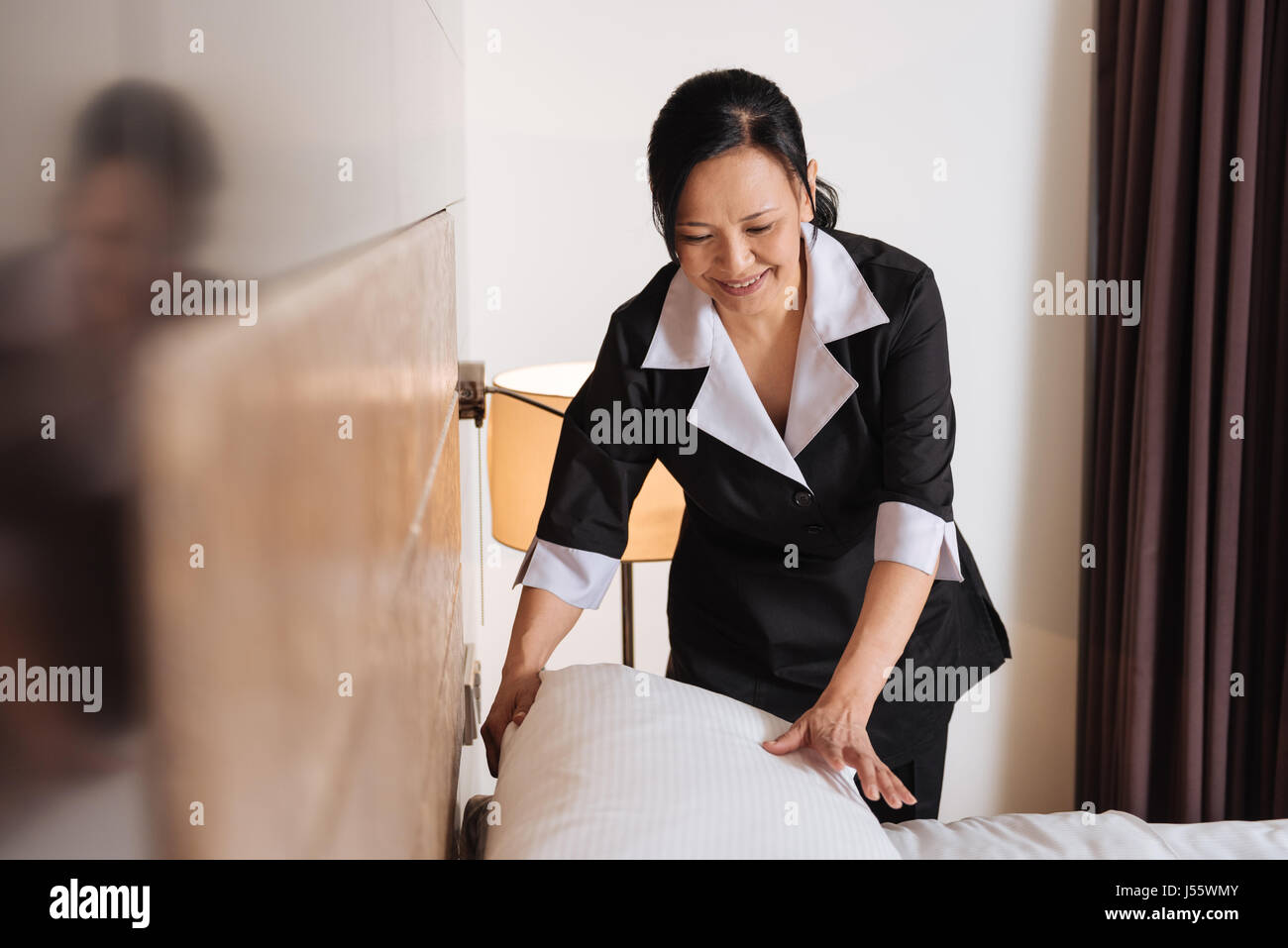 Cheerful positive woman leaning over the bed Stock Photo - Alamy
