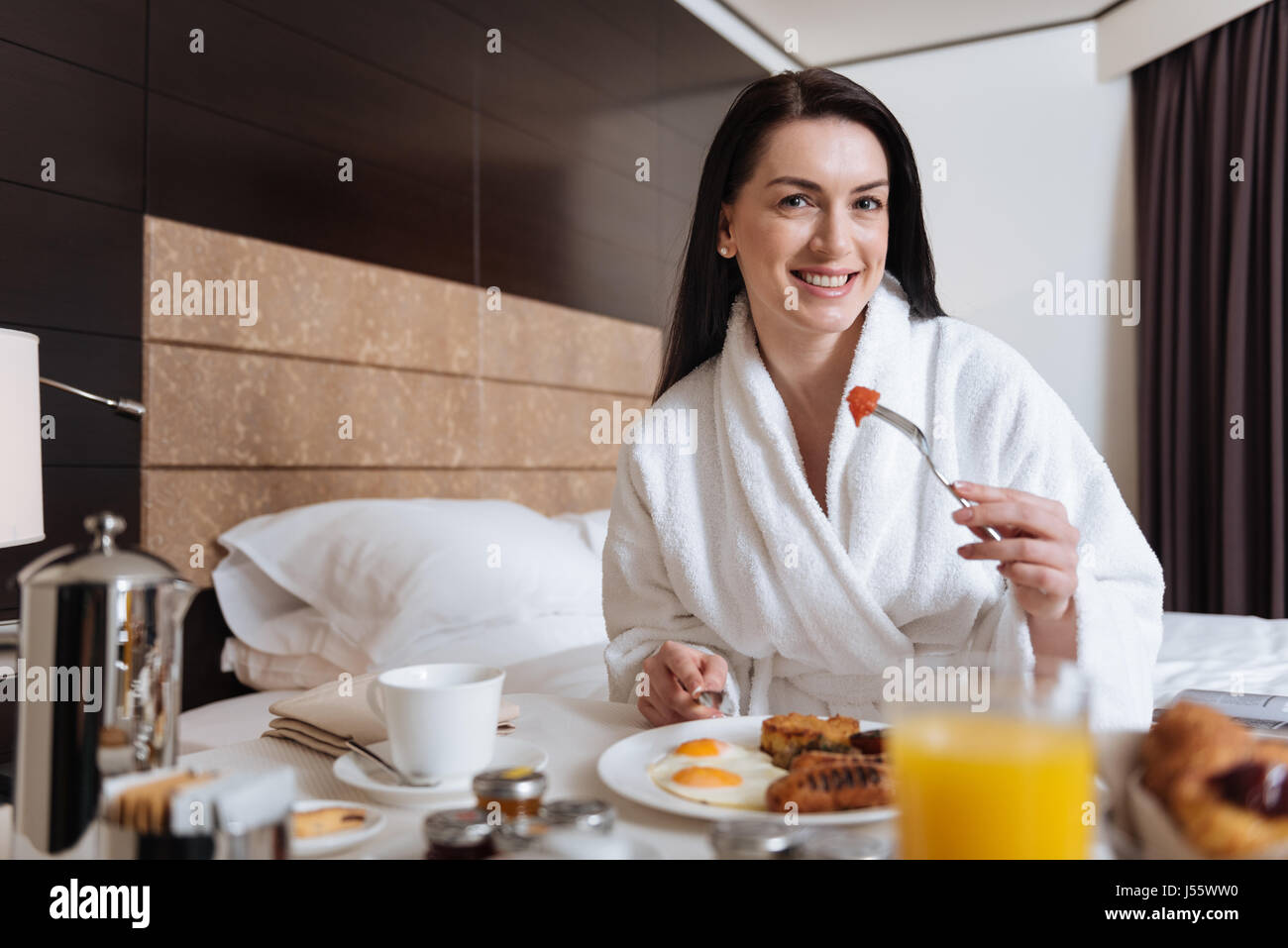 Beautiful happy woman eating her breakfast Stock Photo - Alamy