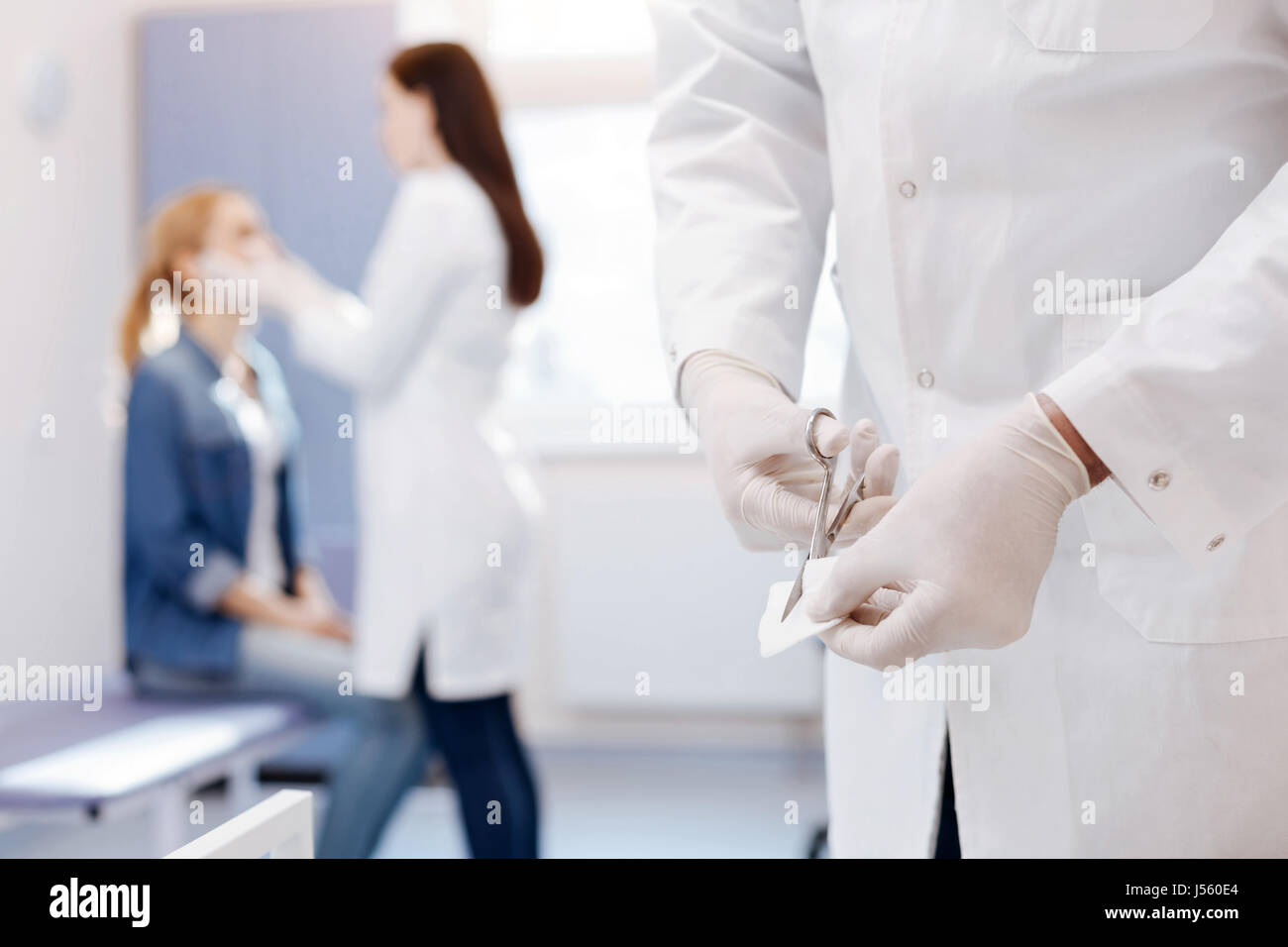 Pleasant male doctor using scissors Stock Photo - Alamy