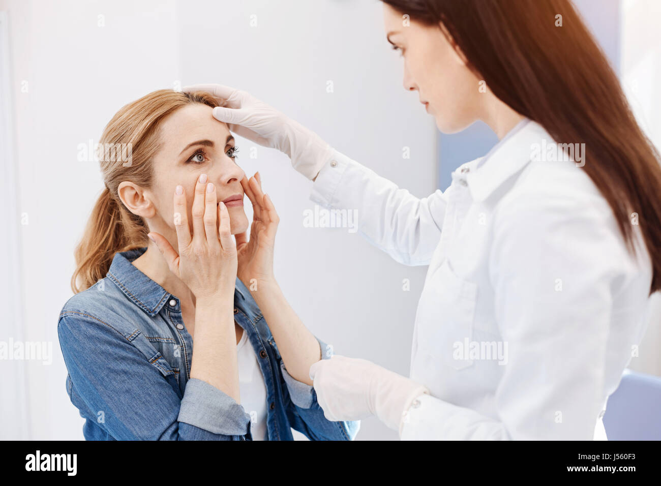 Beautiful good looking woman holding her cheeks Stock Photo - Alamy