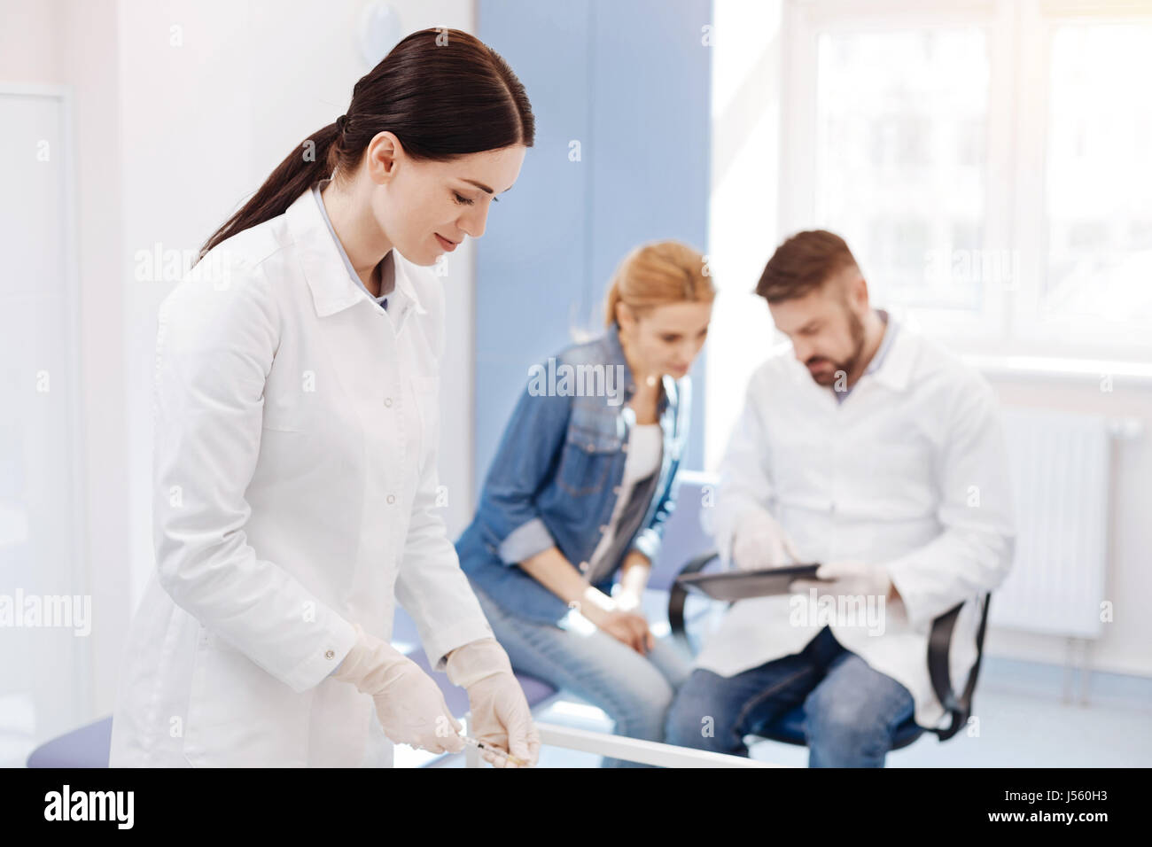 Nice professional doctor preparing a syringe Stock Photo - Alamy