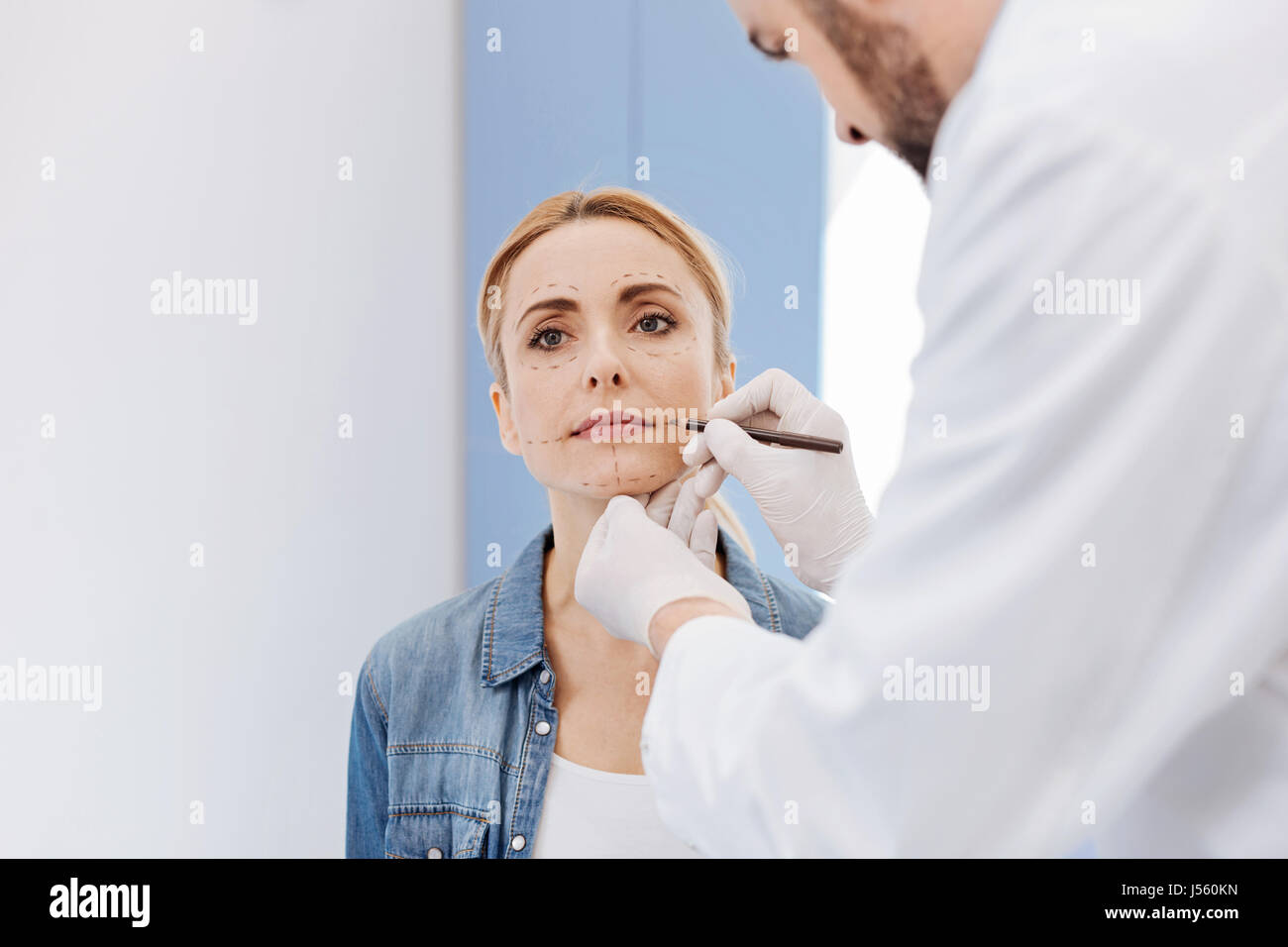 Professional plastic surgeon drawing correction lines Stock Photo - Alamy