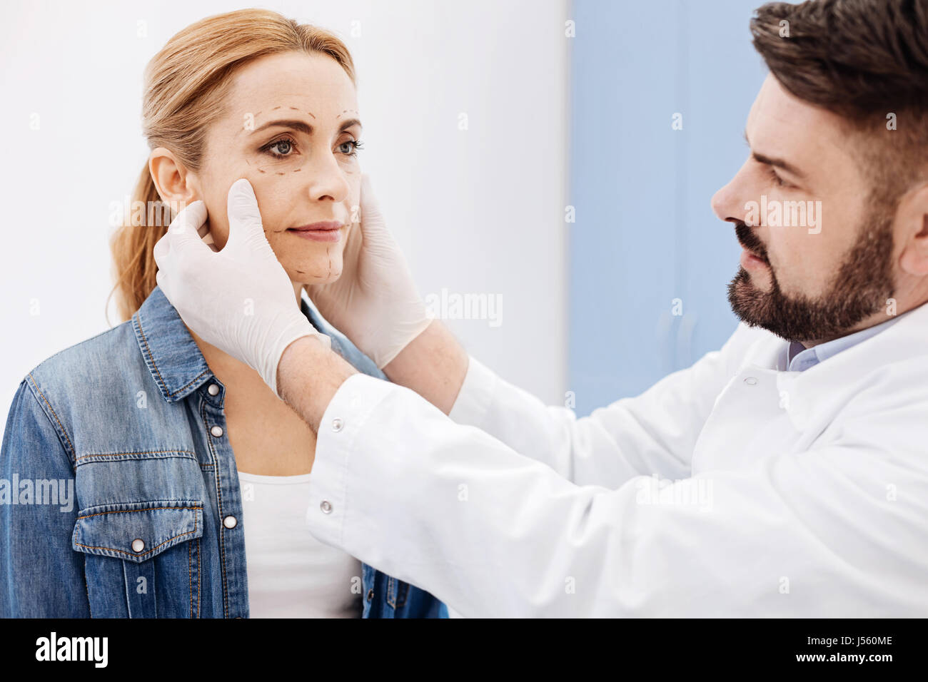 Handsome nice doctor holding his patients face Stock Photo - Alamy