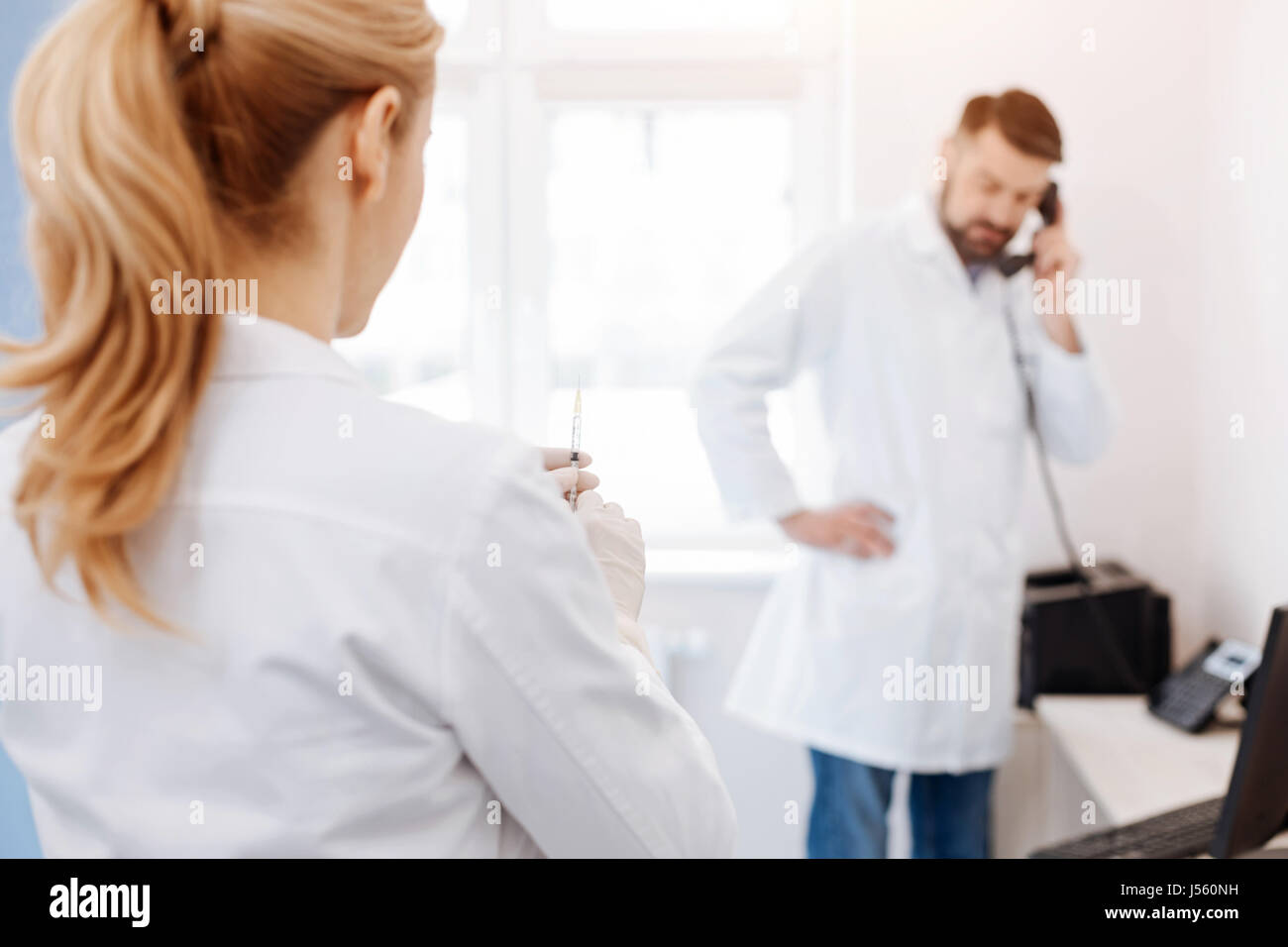 Nice attractive doctor being ready to do an injection Stock Photo - Alamy