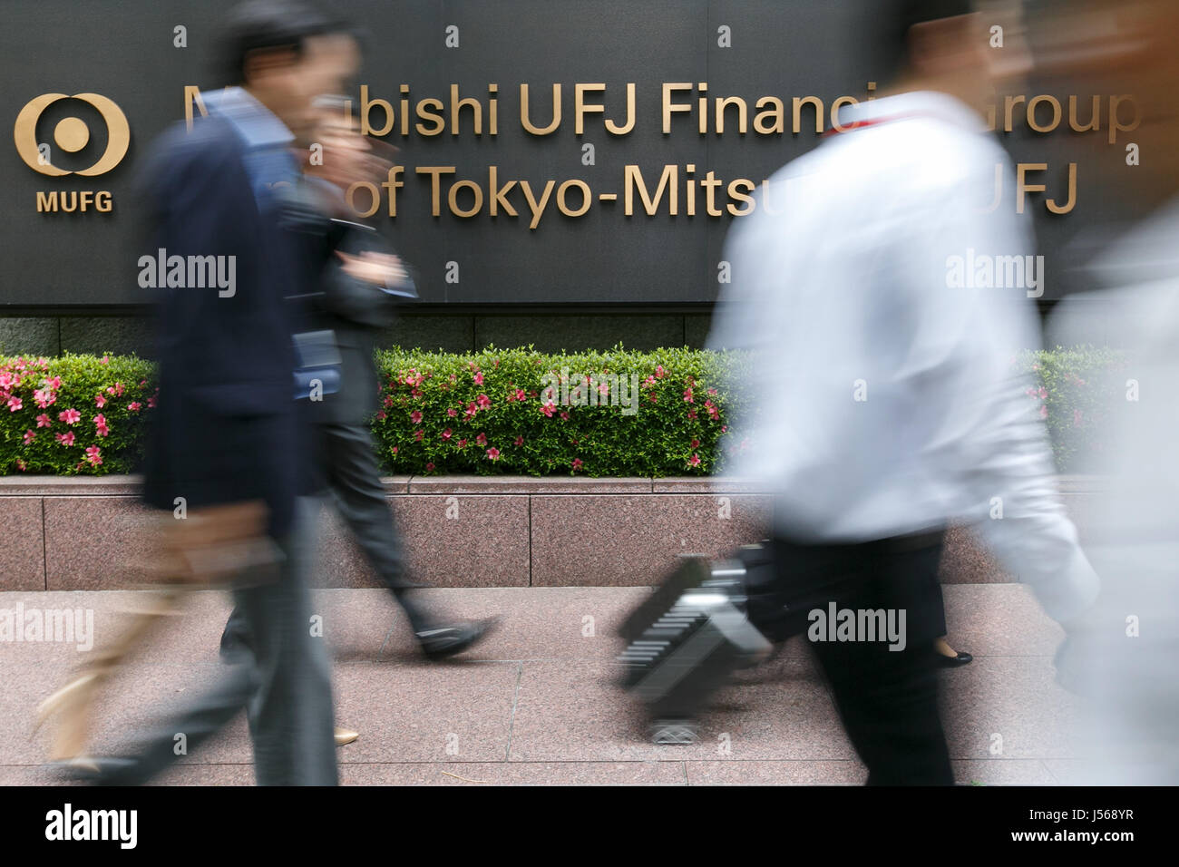 Tokyo, Japan. 17th May, 2017. Pedestrians walk past a signboard of Bank ...