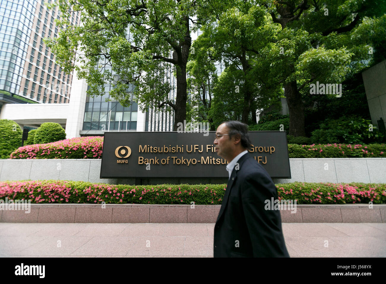 Tokyo, Japan. 17th May, 2017. A man walks past a signboard of Bank of ...