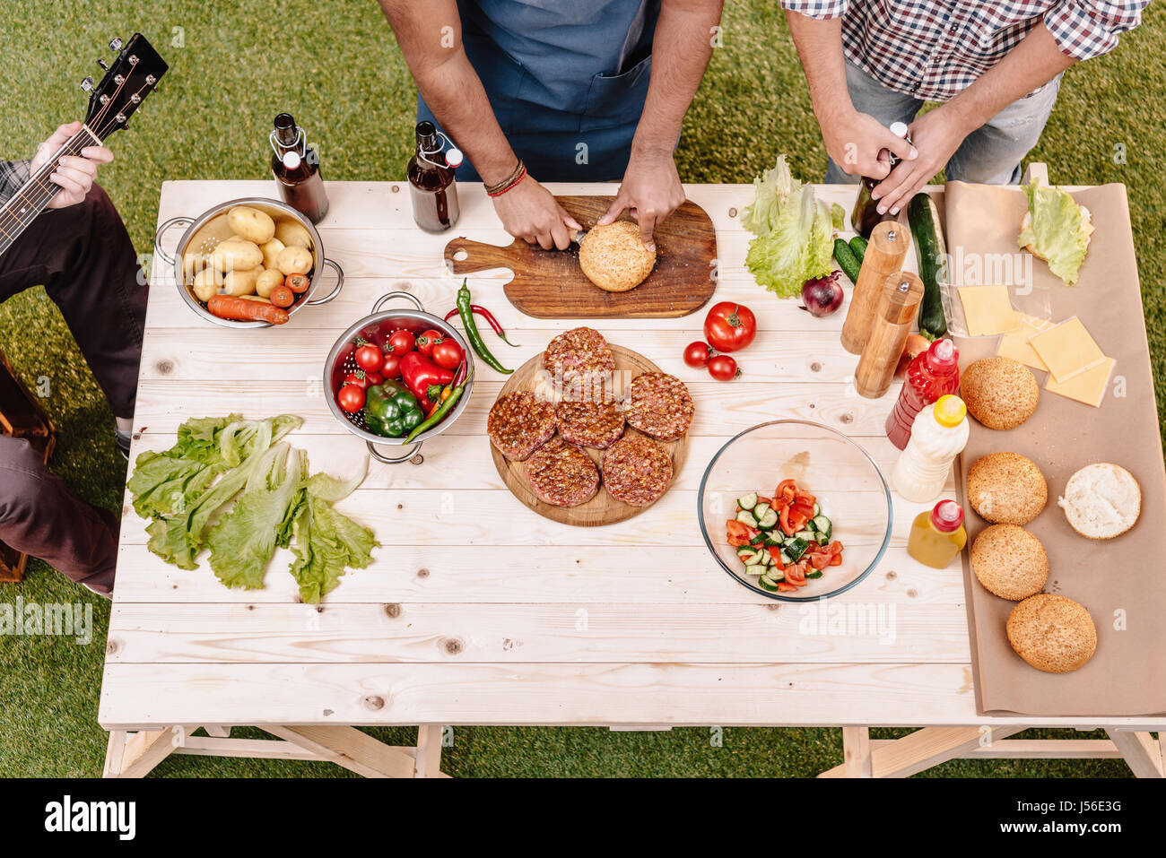 elevated cropped view of friends making burgers on table outdoors Stock ...